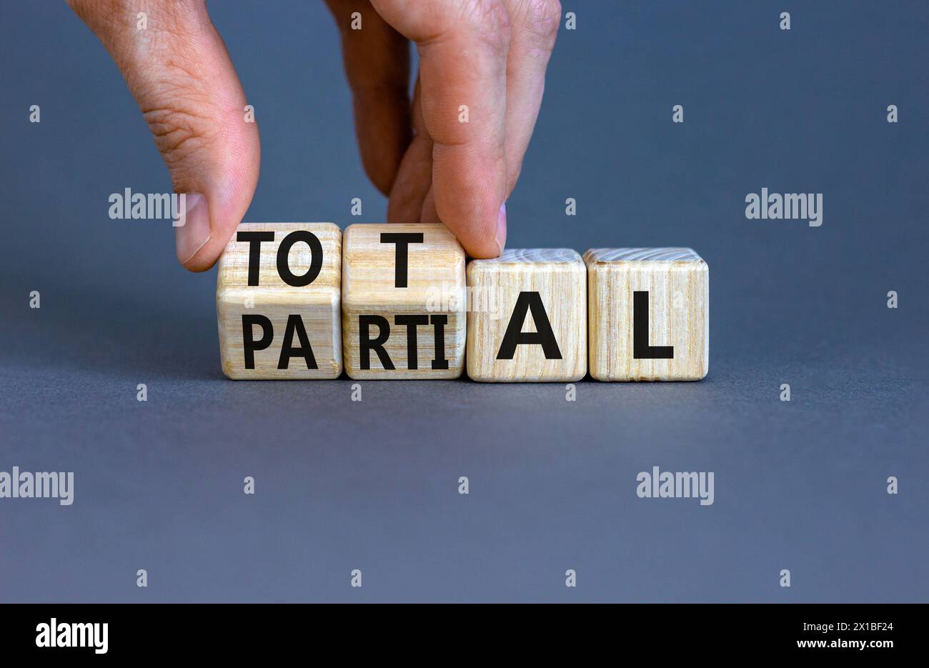 Total or partial symbol. Businessman turns beautiful wooden cubes and ...