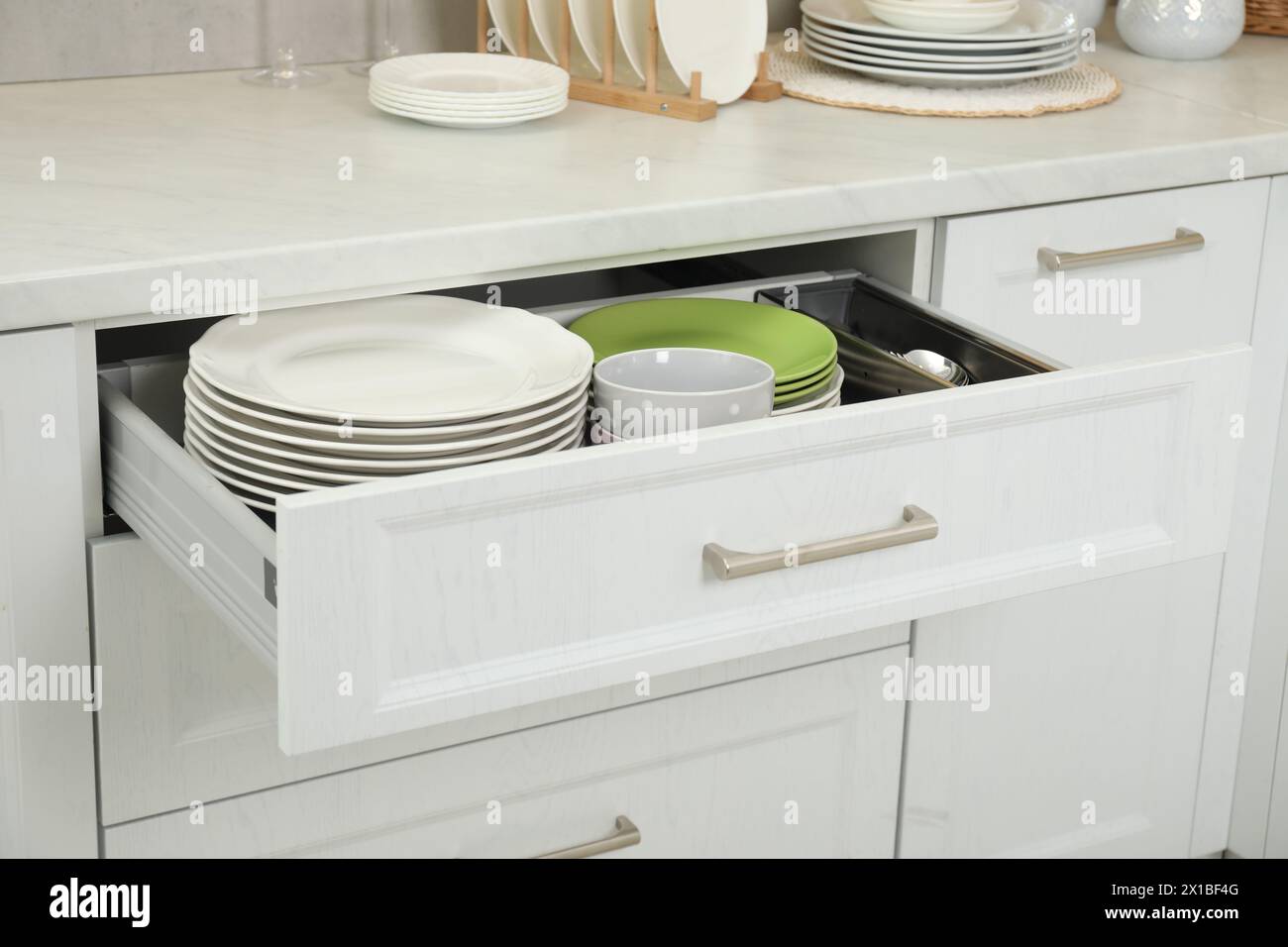Clean plates and bowl in drawer indoors Stock Photo - Alamy