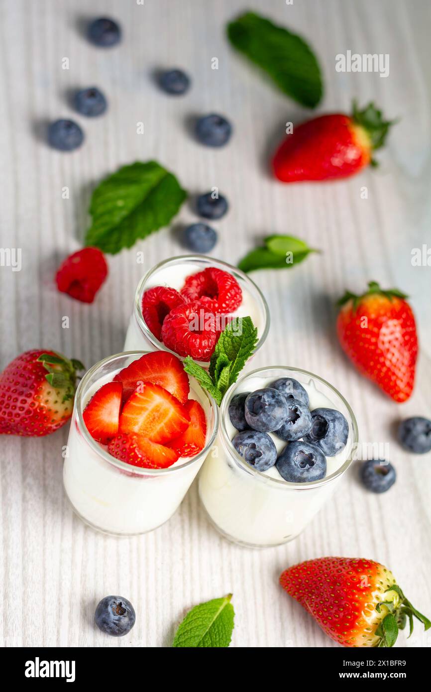 3 mini fruity yoghurt pots on grey wood background Stock Photo - Alamy