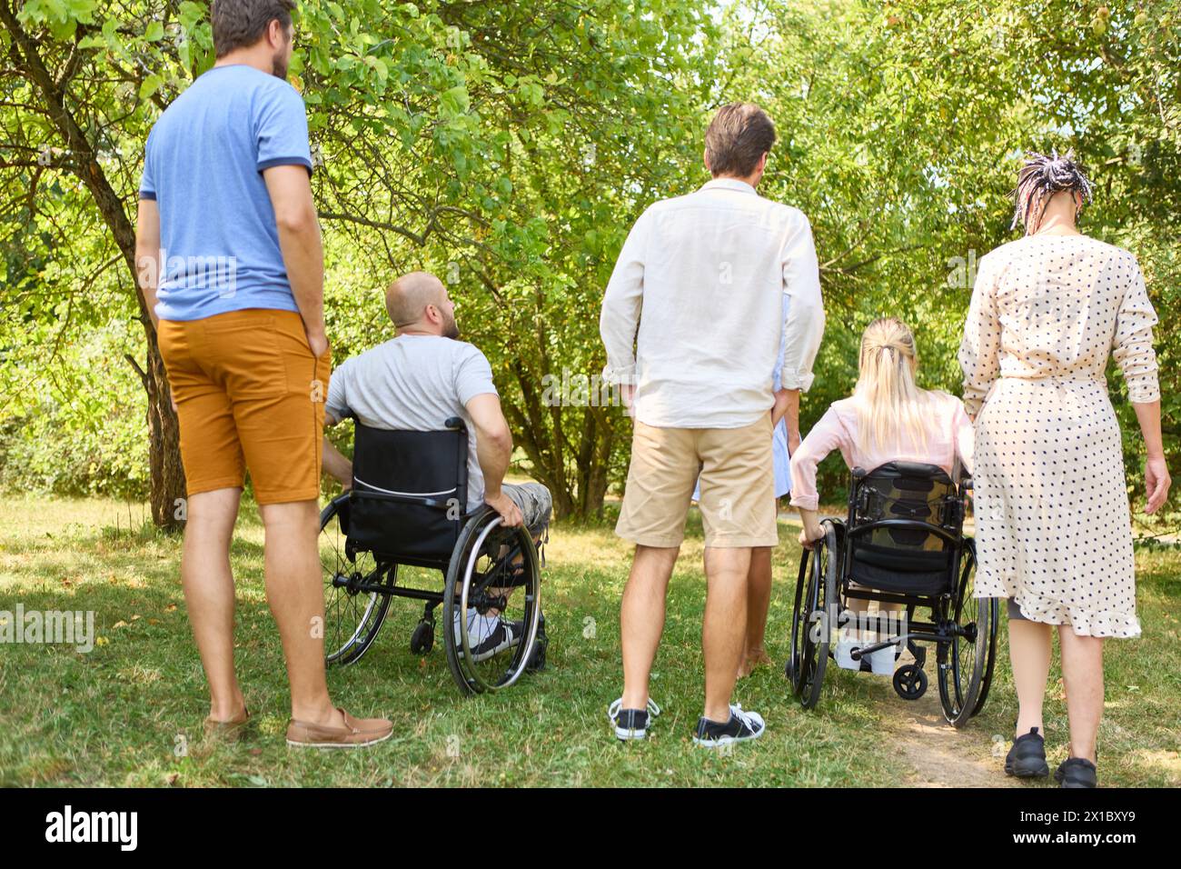 Group of friends with two people using wheelchairs enjoying nature ...