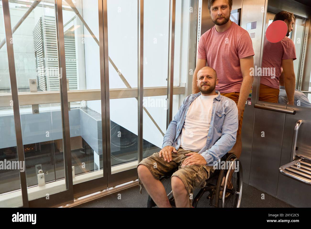 A content person using a wheelchair and a standing companion enjoy a ...