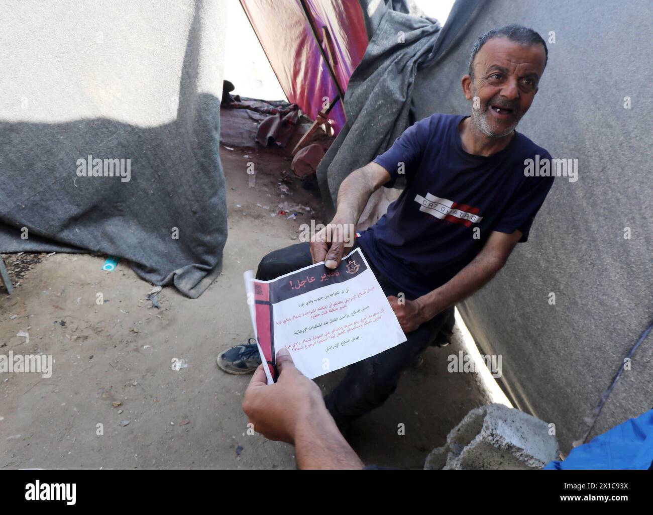 A man reads one of the leaflets dropped by the Israeli army with text ...