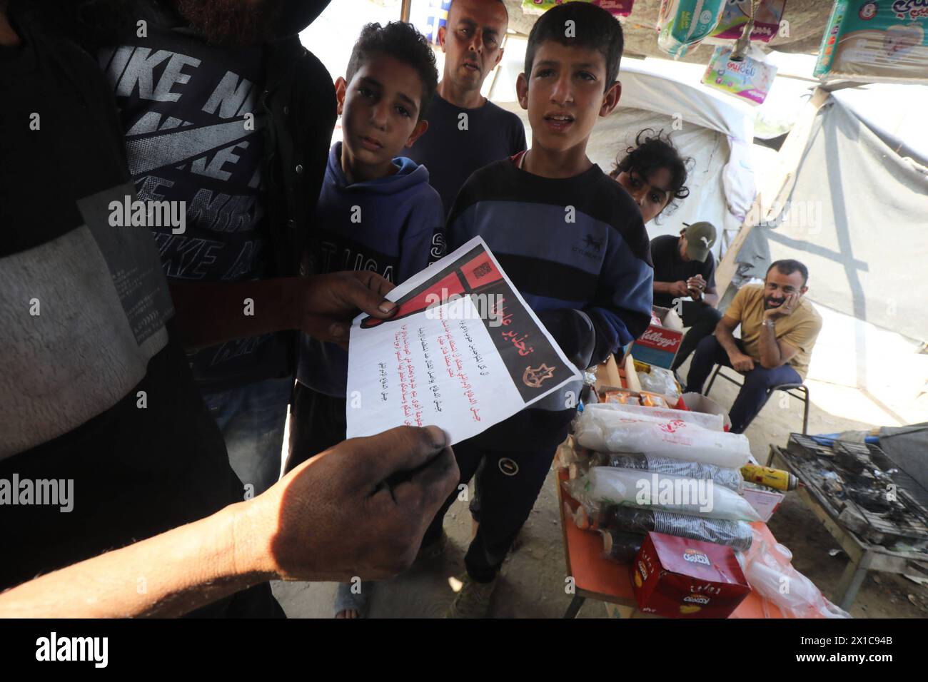 A man reads one of the leaflets dropped by the Israeli army with text ...