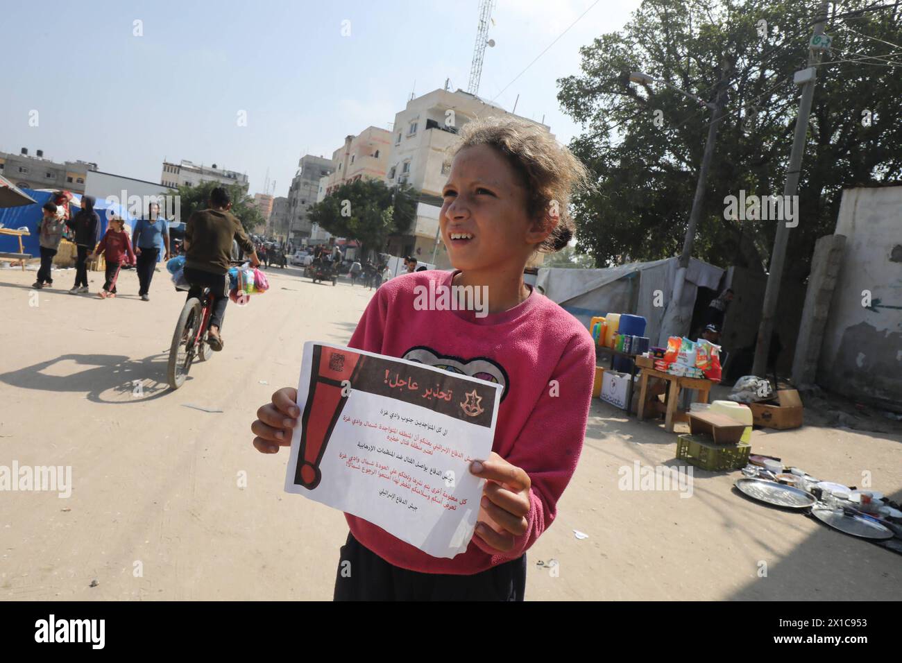 A man reads one of the leaflets dropped by the Israeli army with text ...