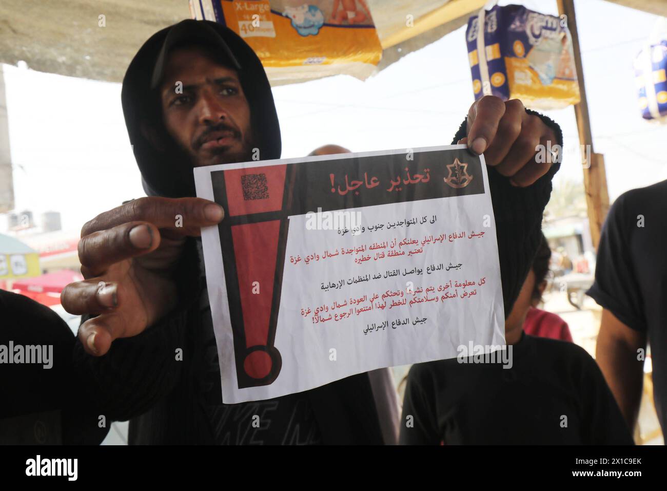 A man reads one of the leaflets dropped by the Israeli army with text ...