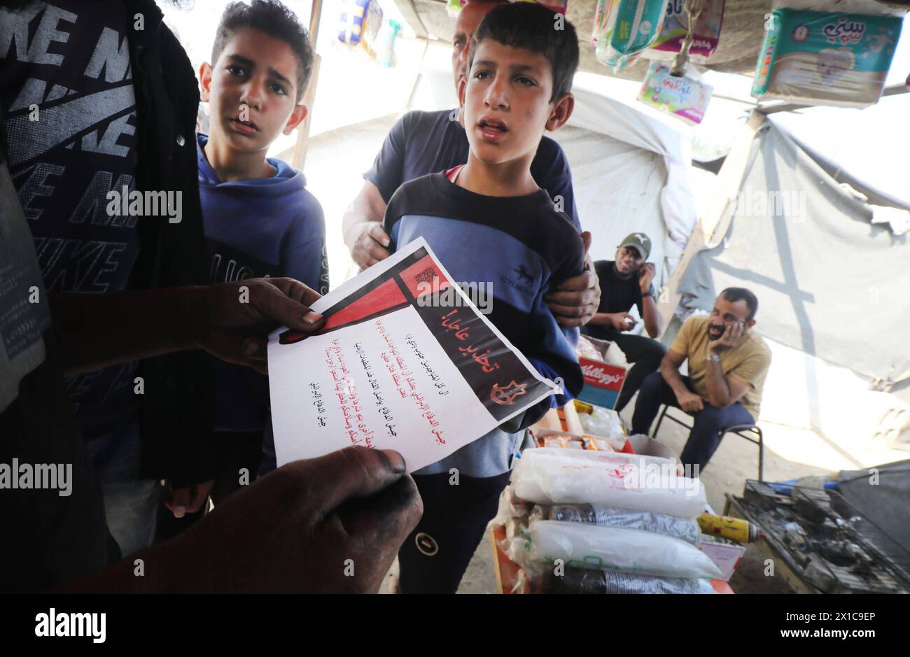 A man reads one of the leaflets dropped by the Israeli army with text ...