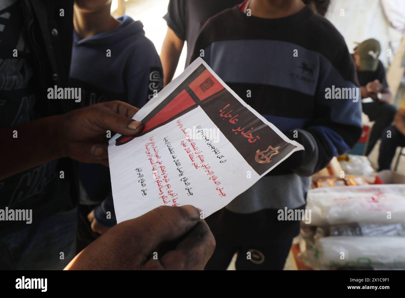 A man reads one of the leaflets dropped by the Israeli army with text ...
