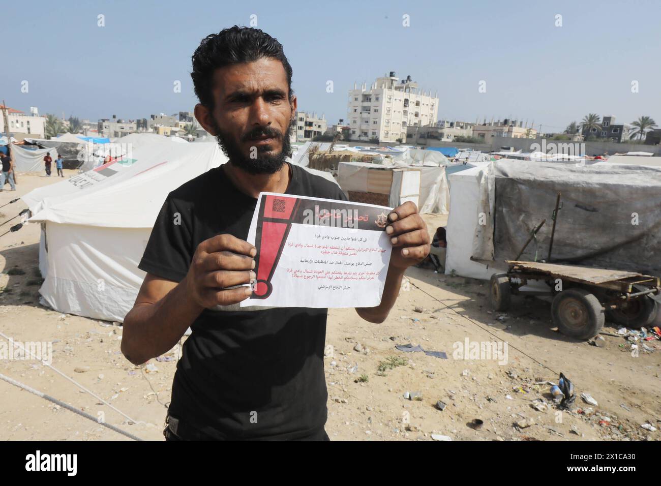 A man reads one of the leaflets dropped by the Israeli army with text ...
