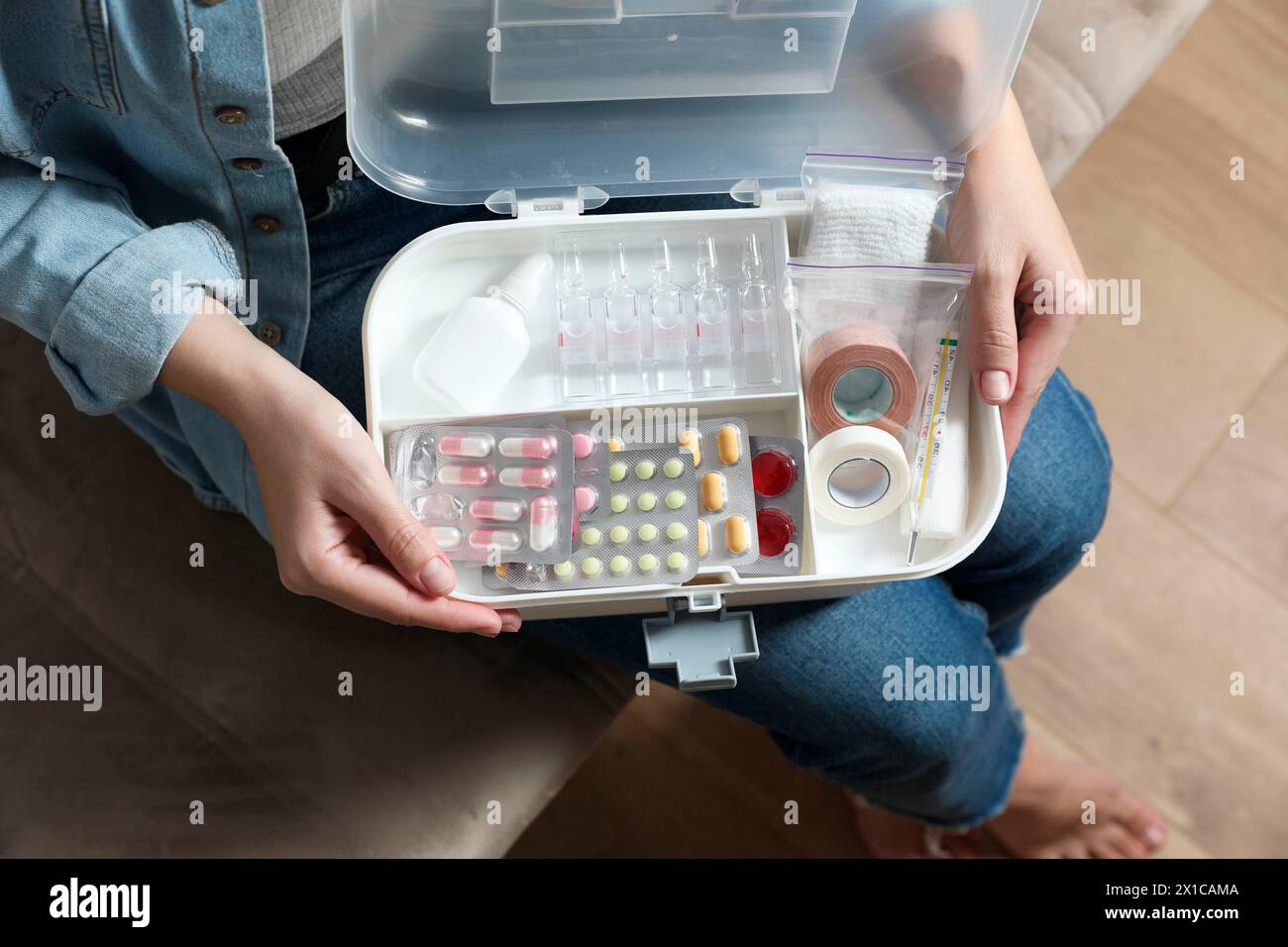 Woman holding first aid kit indoors, top view Stock Photo - Alamy