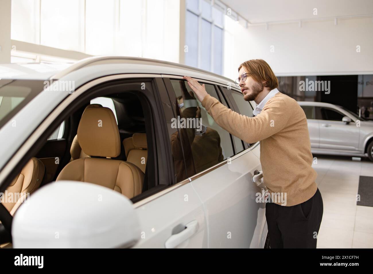 Customer buyer, client, wearing yellow sweater, looking at interior of ...
