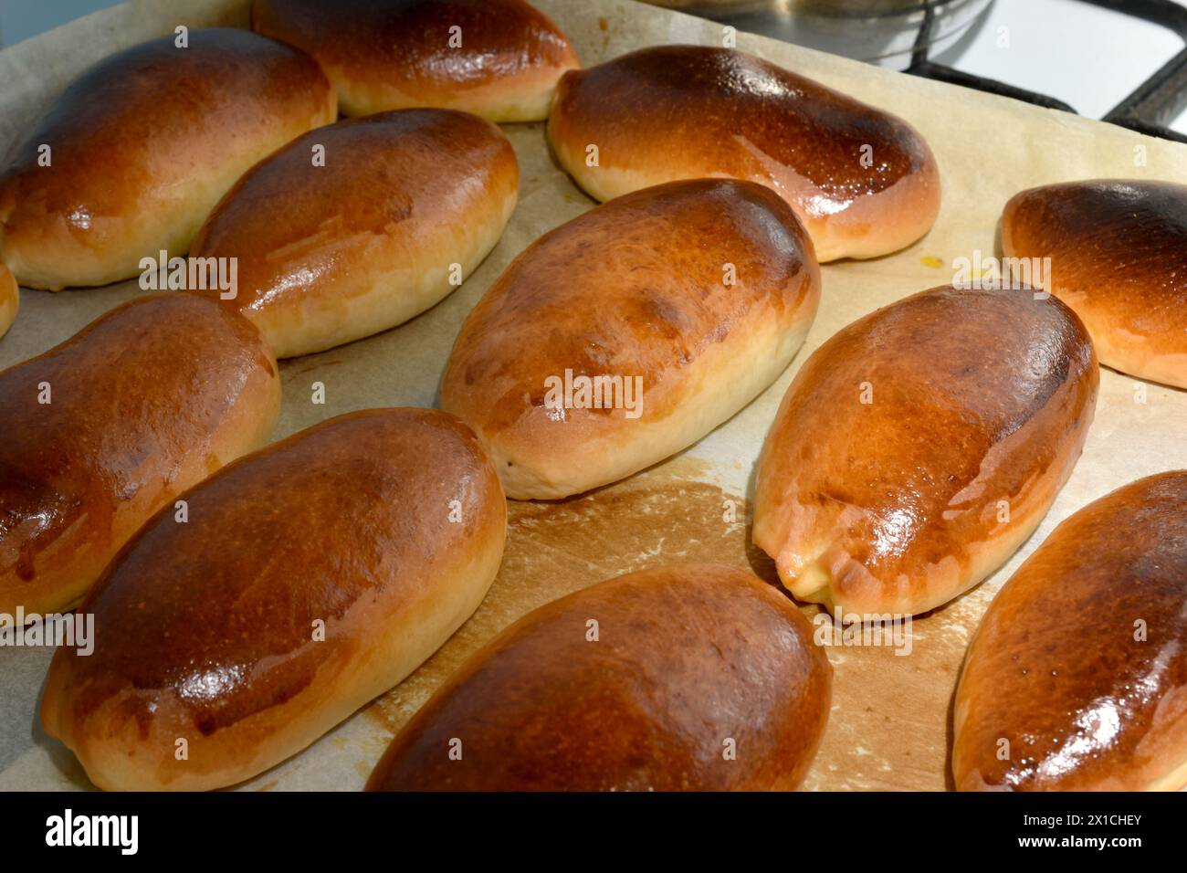 Baked pies, brown in color, lie in rows on a baking sheet Stock Photo ...
