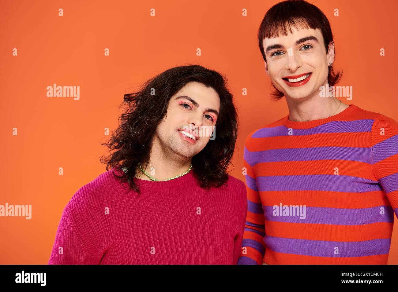 handsome stylish jolly gay friends in vibrant clothes posing happily ...