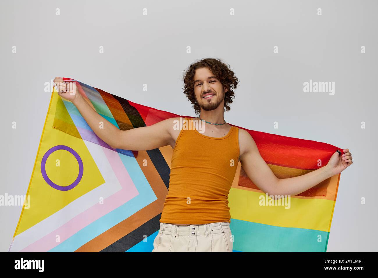 contented alluring gay man with dark hair holding rainbow flag and ...