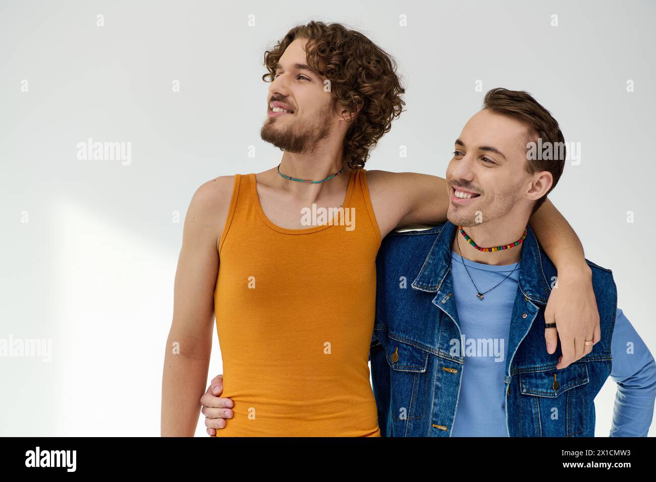 attractive merry lgbt friends in vivid attires looking at each other on ...