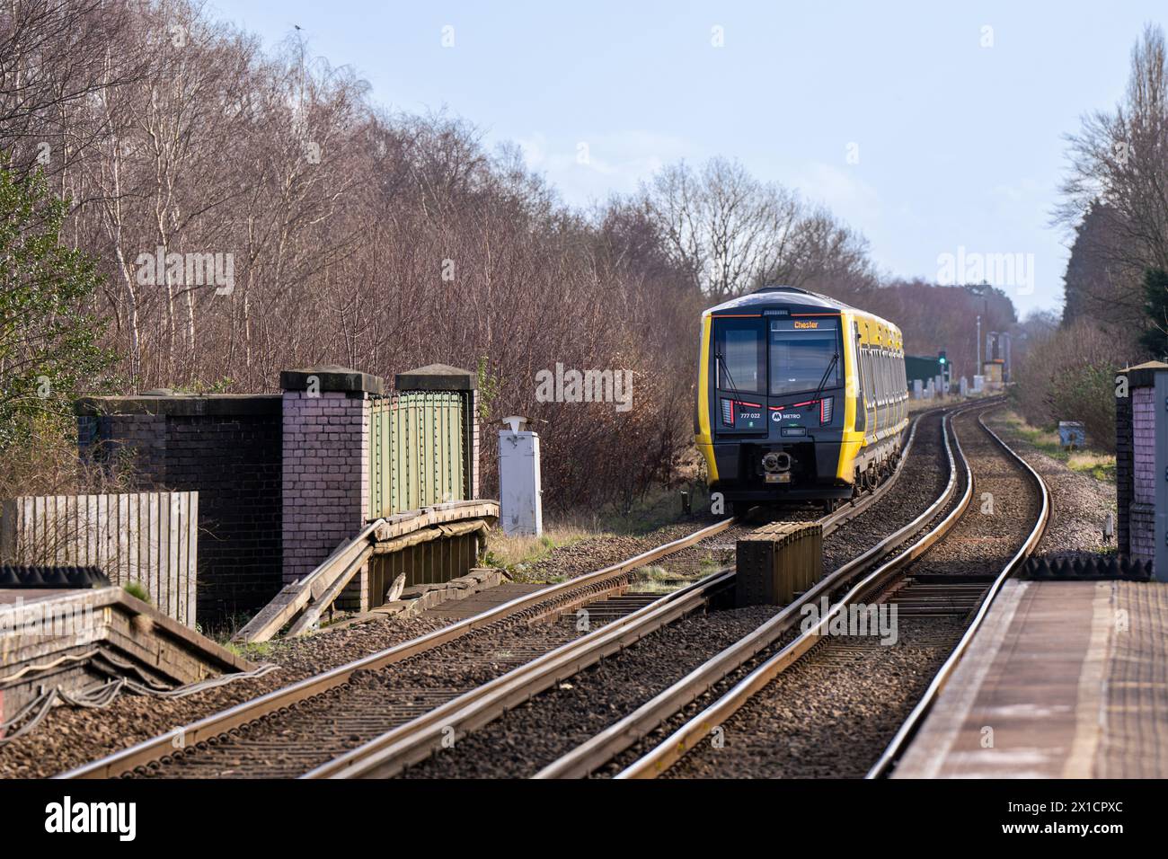 Merseyrail train arriving at station platform Stock Photo - Alamy