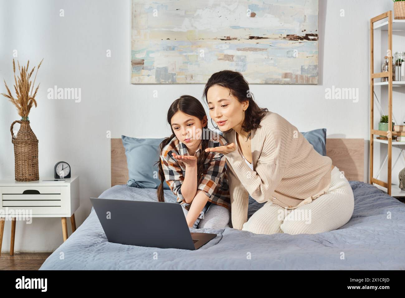 A woman and a girl share a tender moment on a bed while gazing at a ...