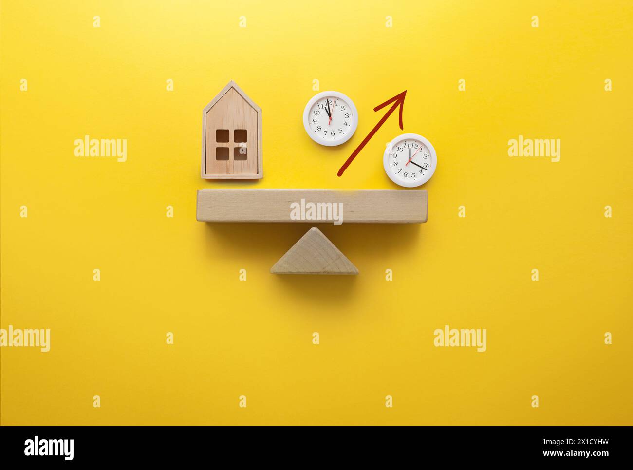 Miniature house and percentage sign with clock faces balanced on a ...