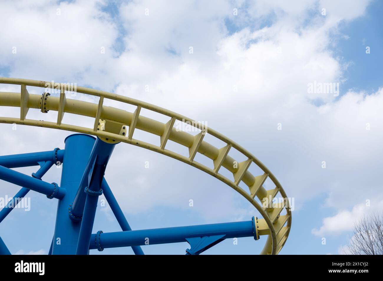 Yellow and blue track for the ride in amusement park against blue sky ...