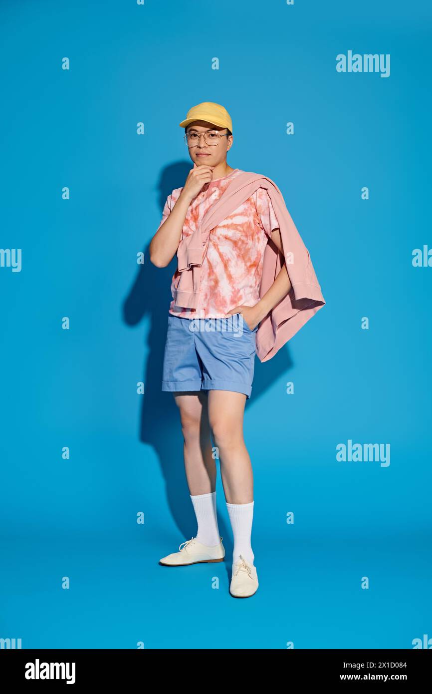 A stylish, good-looking young man poses actively in trendy attire ...