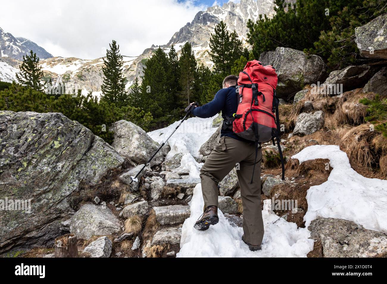 A tourist walks on a hiking trail dressed in relatively light clothes ...