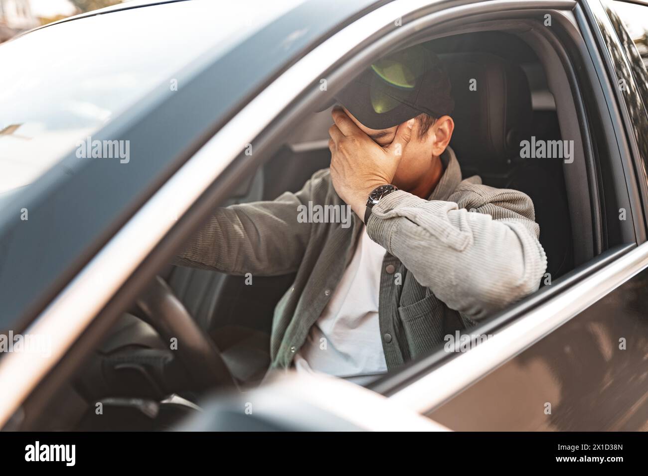 Annoyed tired young man driving his car with open window Stock Photo ...