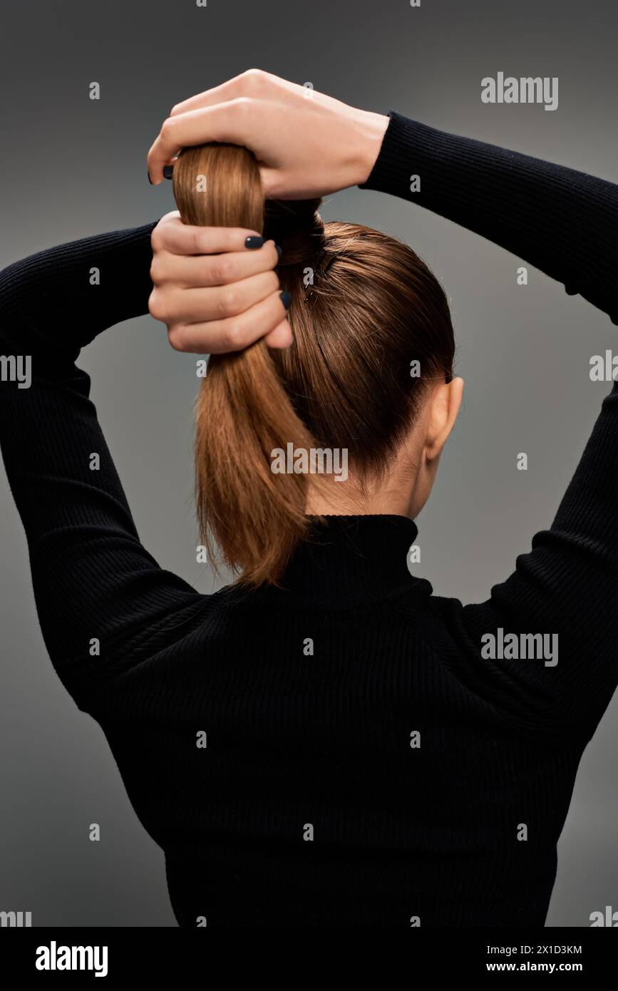 Back view, young woman with long hair tied in a ponytail exudes beauty ...