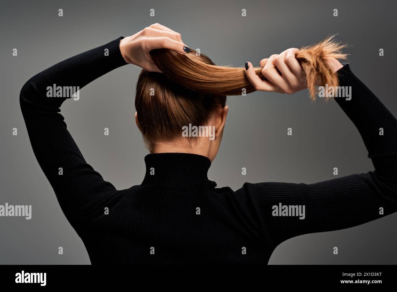 Back view of young, beautiful woman with long hair styled in a ponytail ...
