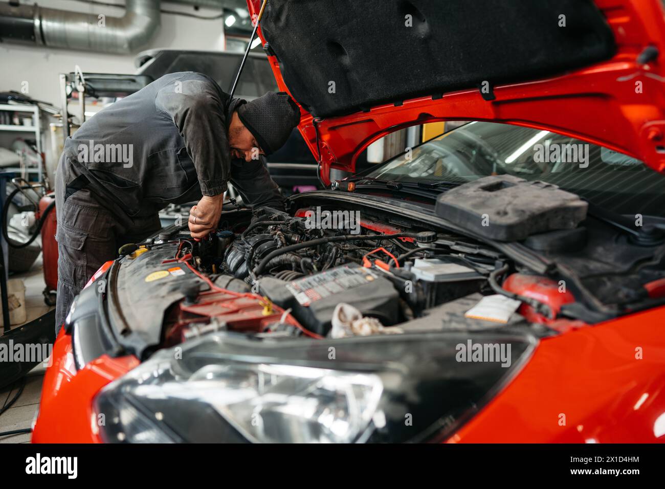 Auto mechanic checking engine in garage repair service Stock Photo - Alamy