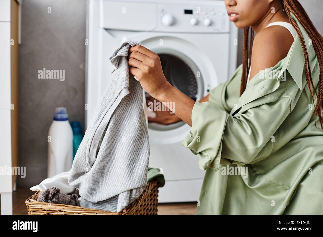 An African American woman with afro braids is seen drying her clothes ...