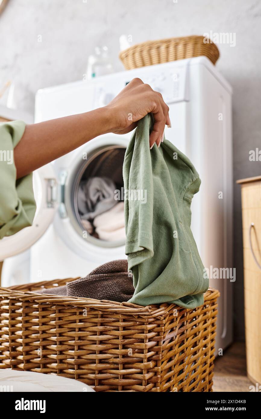 African American woman with afro braids holding a laundry bag in front ...