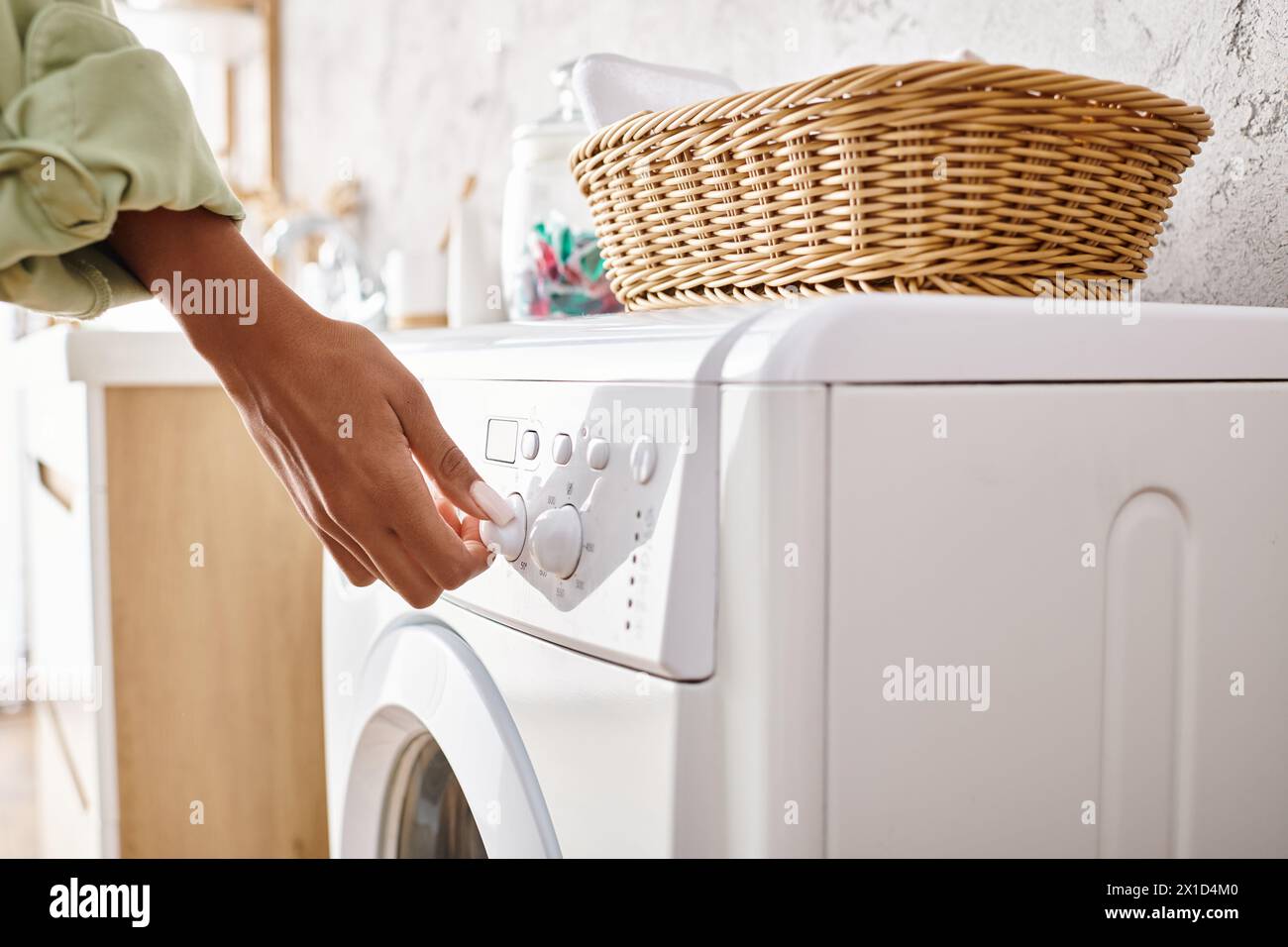 African American woman doing laundry by hand-loading clothes into a washing machine Stock Photo ...