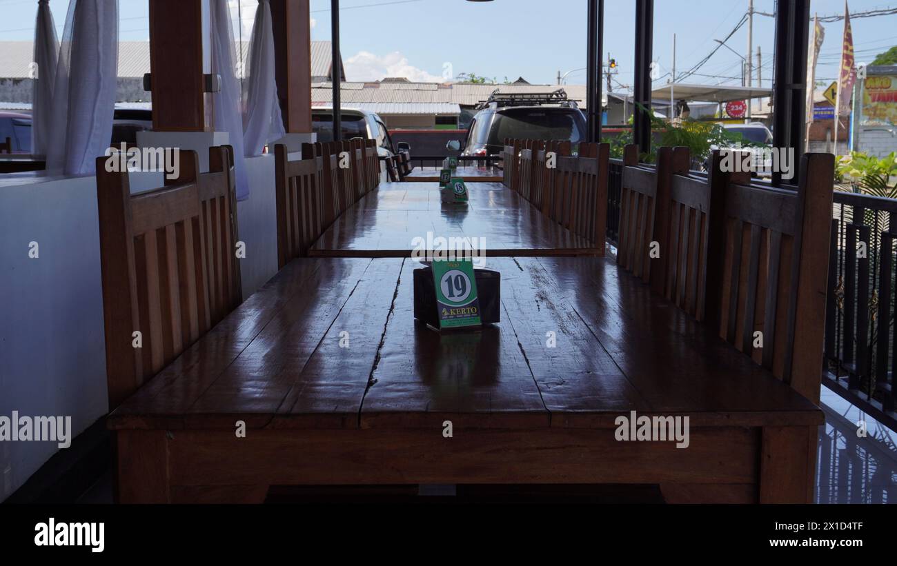 A long wooden dining table in a restaurant Stock Photo - Alamy
