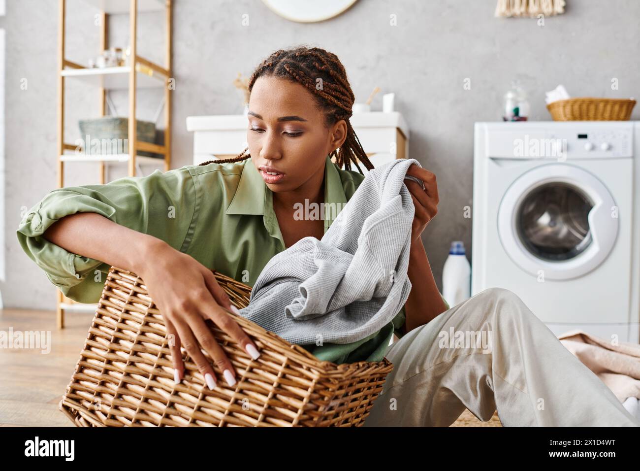 An African American woman with afro braids organizes laundry in a ...