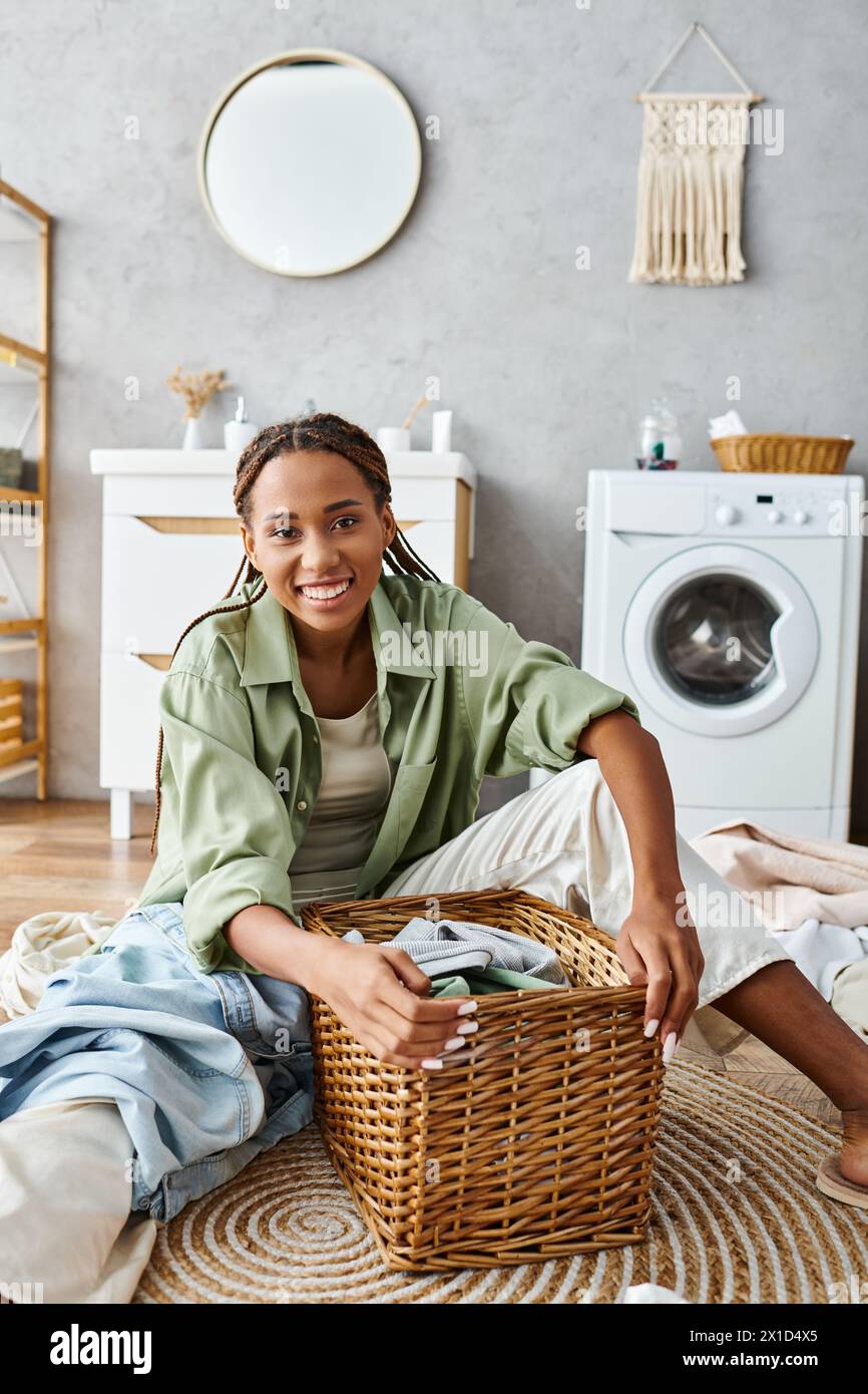 An African American woman with afro braids is sitting on the floor ...