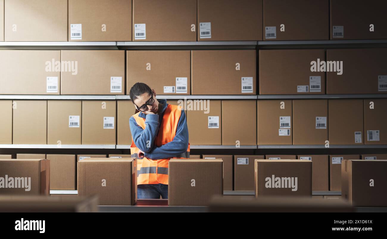 Exhausted female warehouse worker sleeping at work, work burnout ...