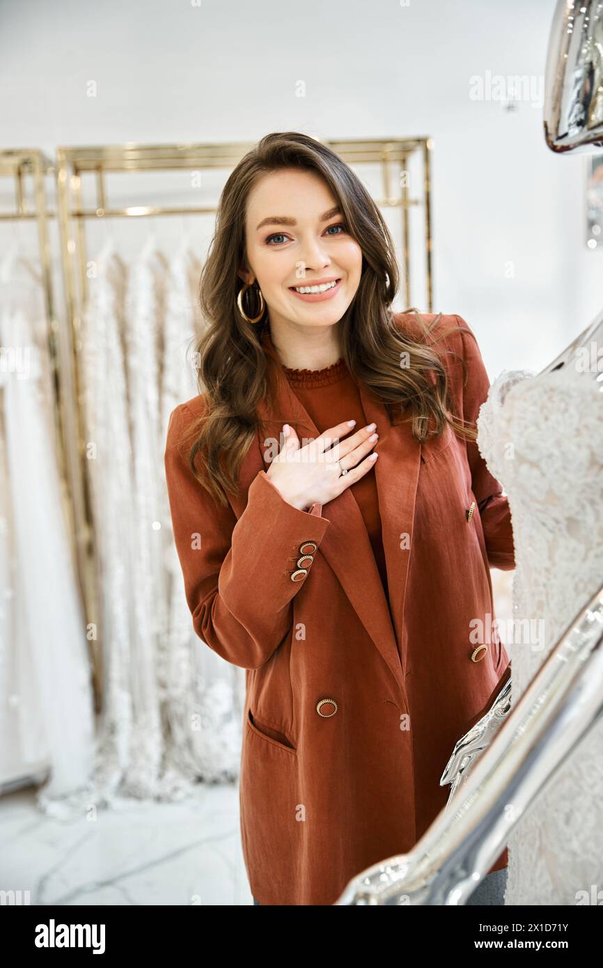 A young bride explores a rack of dresses, contemplating her wedding day ...