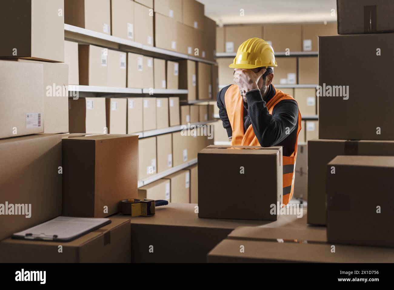 Tired warehouse worker having a bad backache at work, he is feeling ...