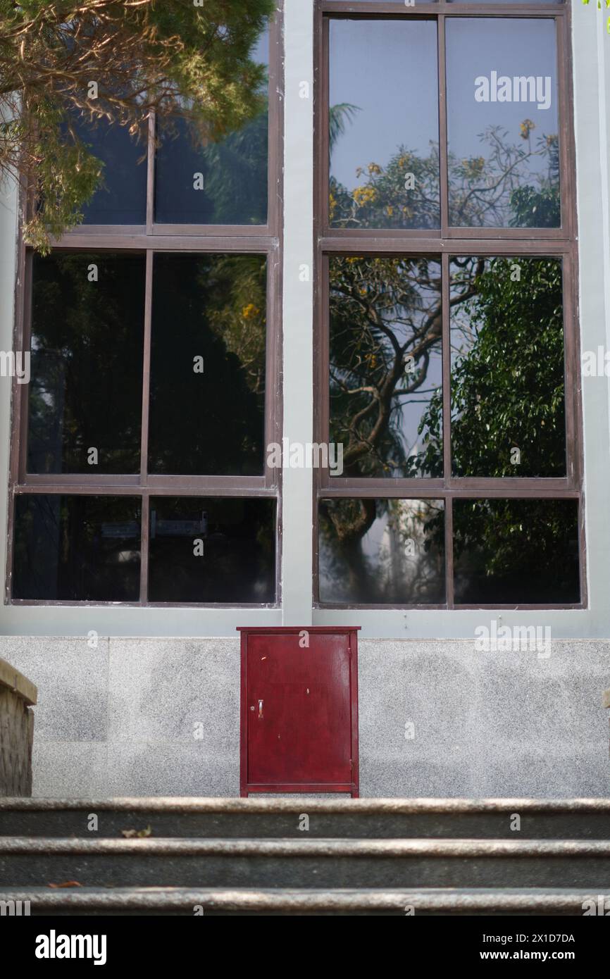 A red iron box with a black window and gray walls as a background Stock ...
