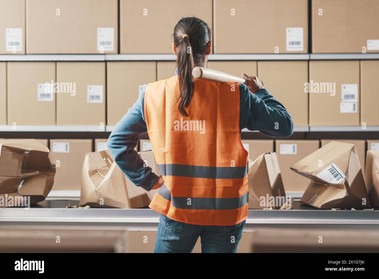 Angry rebellious warehouse worker smashing boxes on the conveyor belt ...
