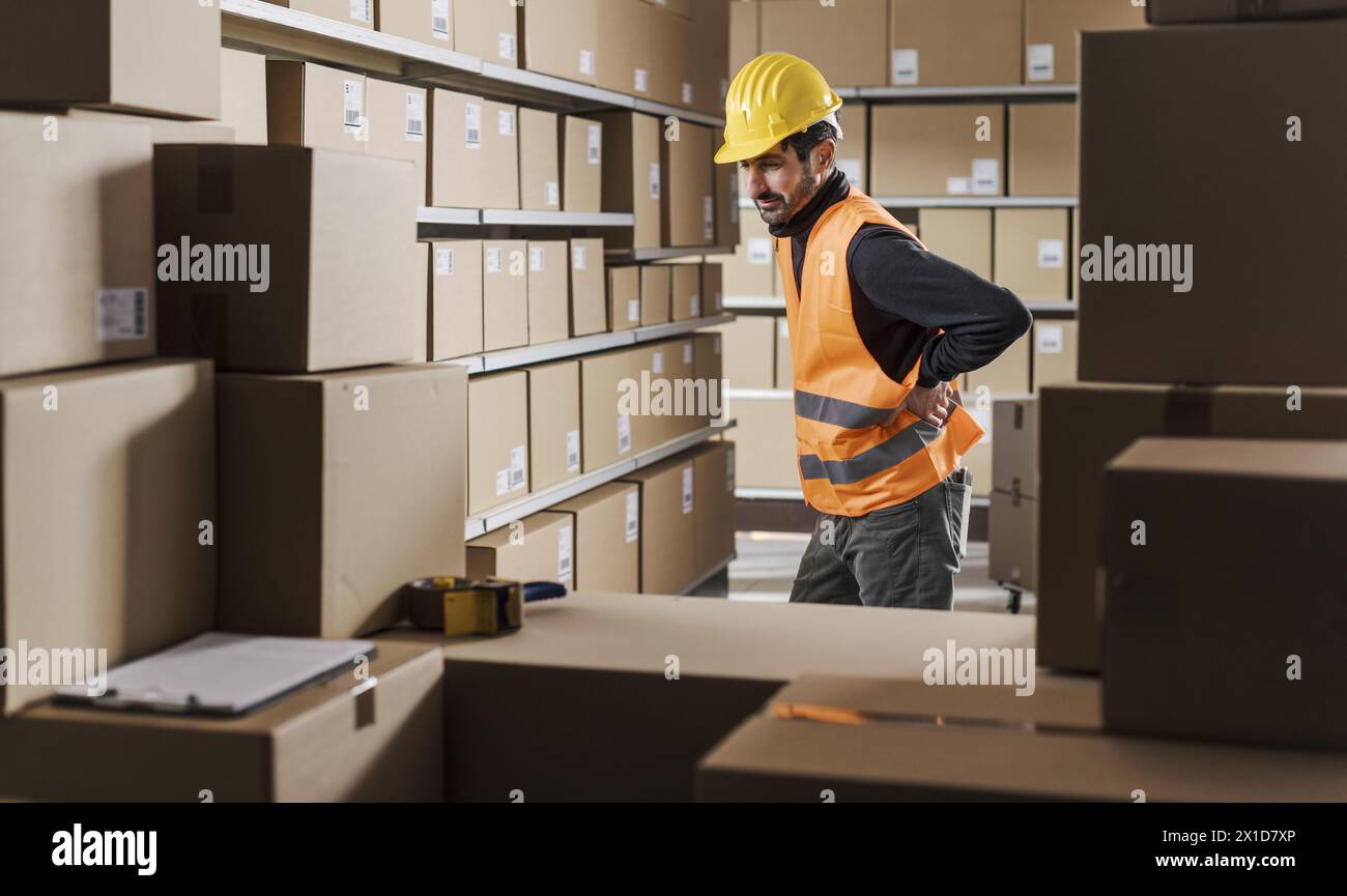Tired warehouse worker having a bad back pain at work Stock Photo - Alamy