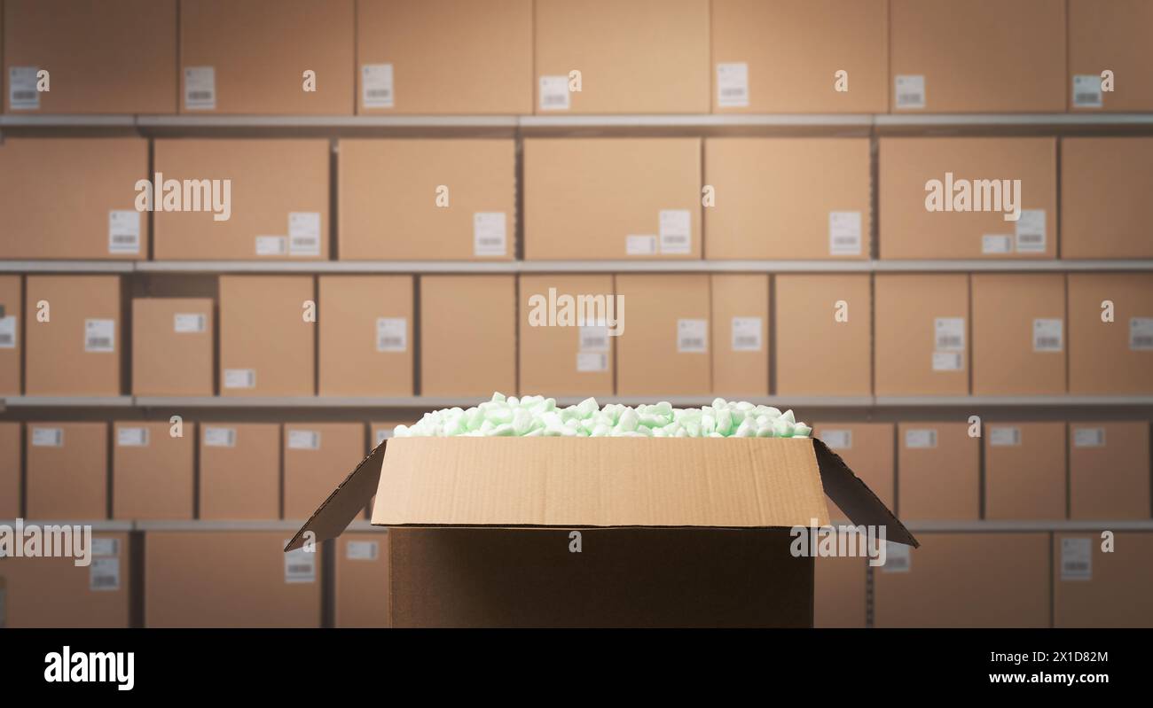 Open delivery box filled with packing chips, warehouse shelves with ...
