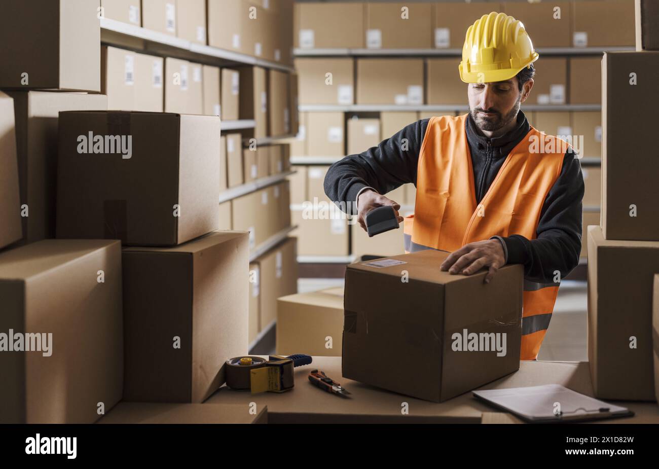 Warehouse clerk scanning labels on packages, delivery and logistics ...