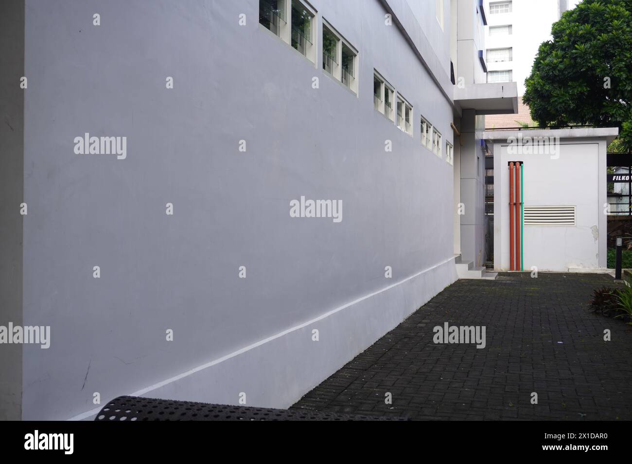 The path beside a minimalist building leads to a small room with ...