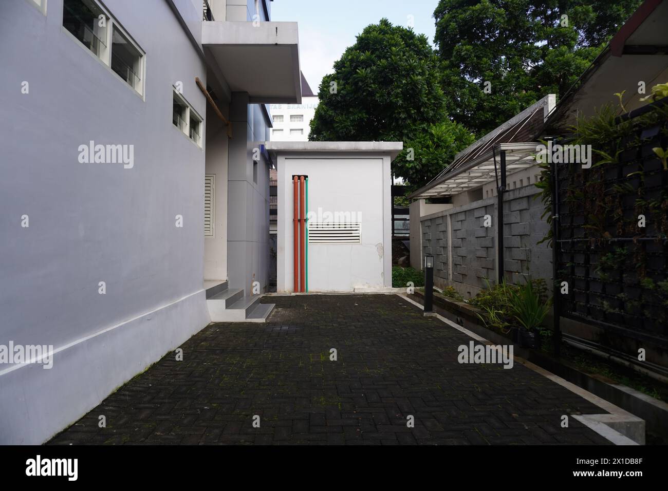 The path beside a minimalist building leads to a small room with ...