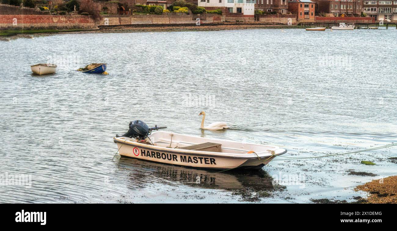A harbour master's boat moored alongside the harbour wall in a small ...
