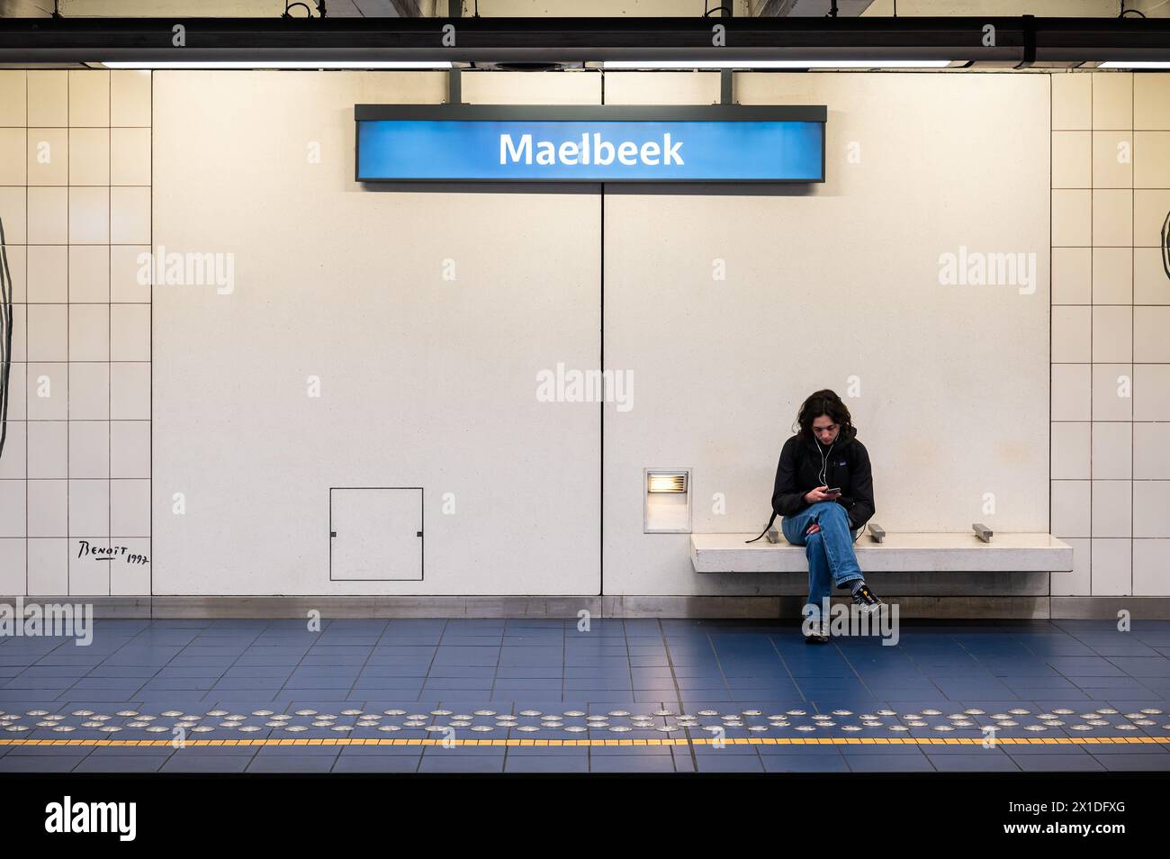 Brussels, Belgium, April 16, 2024 - Young woman waiting for the train ...