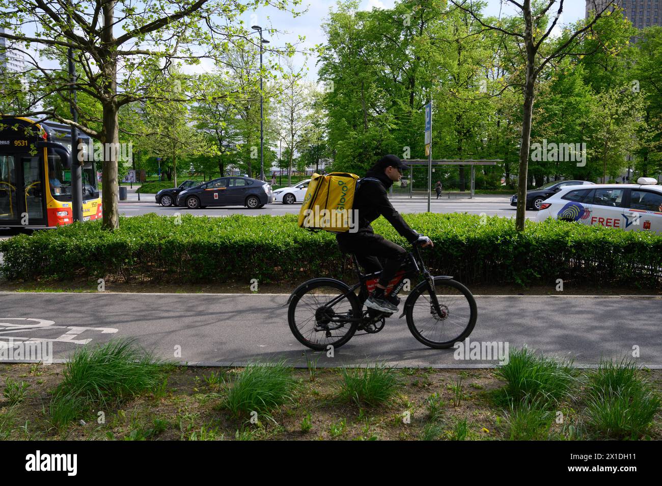 Daily Life in Warsaw. A glovo food delivery courier rides his bike in ...