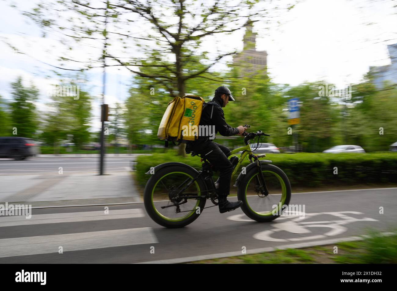 Daily Life in Warsaw. A glovo food delivery courier rides his bike in ...