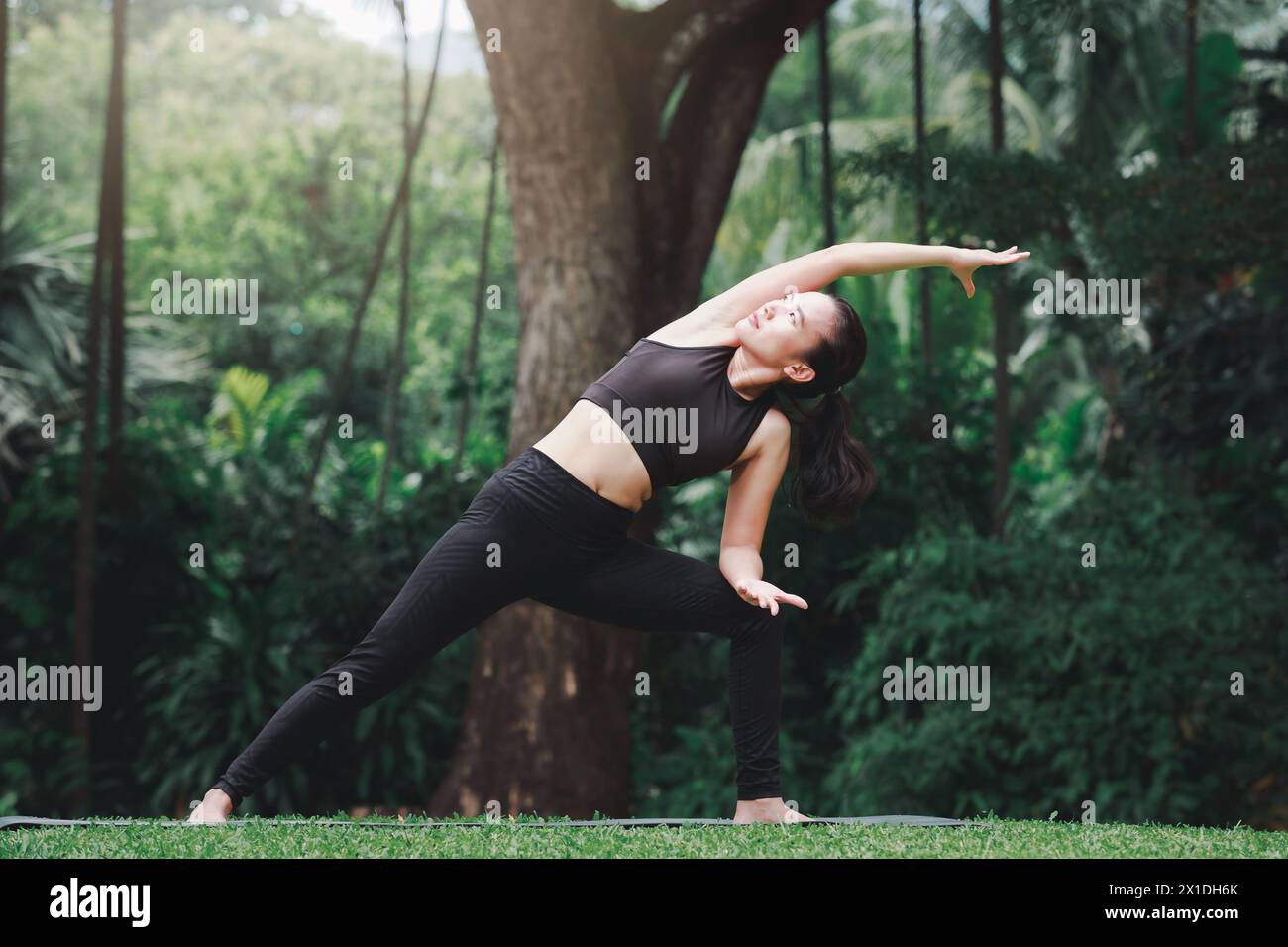 Asian woman practicing yoga she stretching sideways to start preparing ...