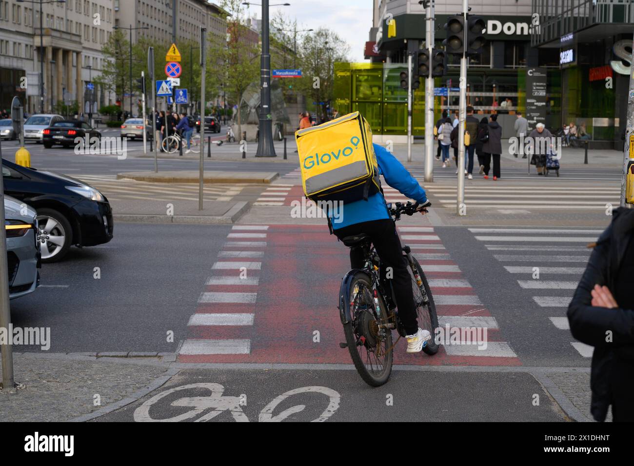 Daily Life in Warsaw. A glovo food delivery courier rides his bike in ...